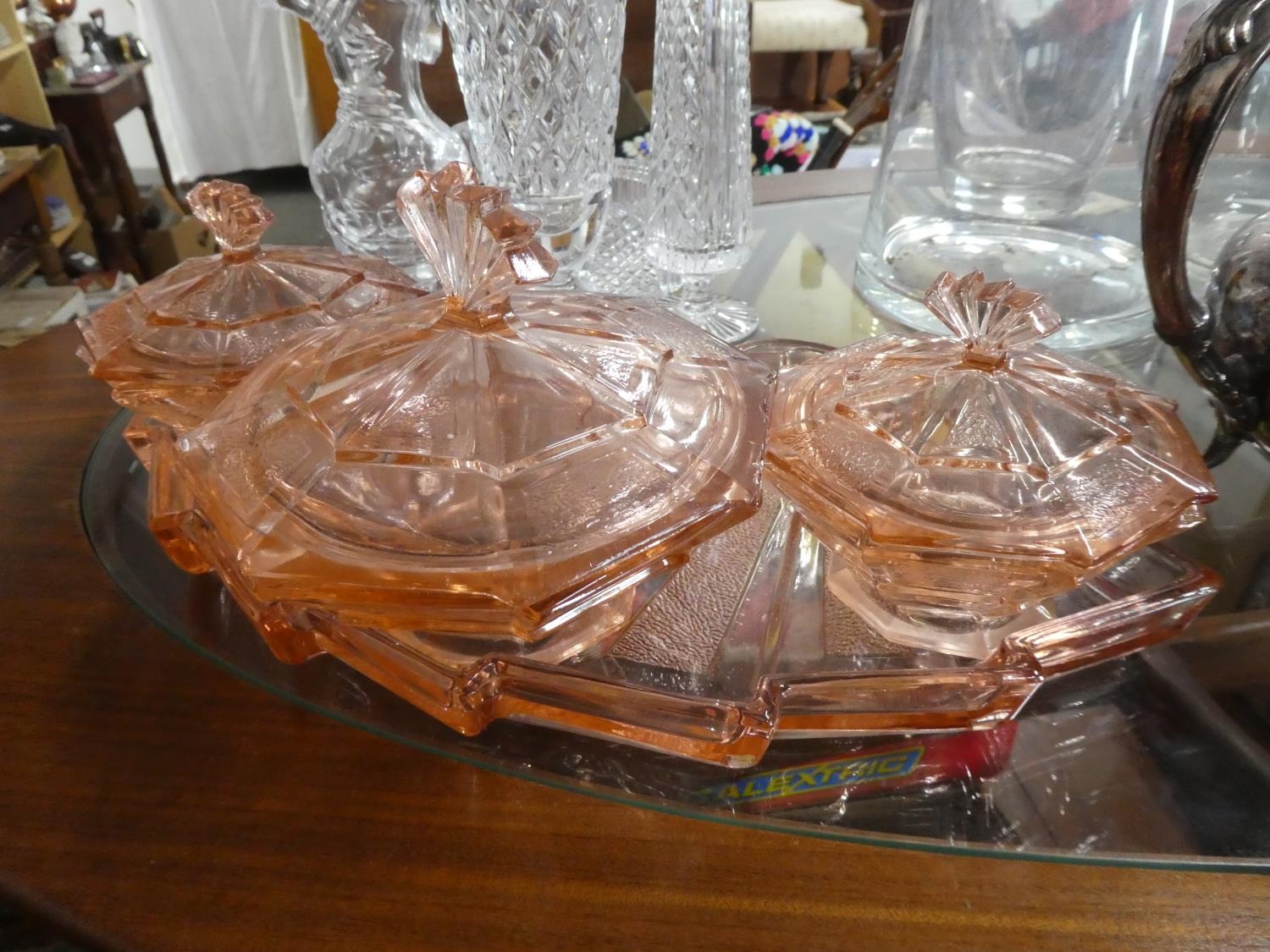An antique pink glass dressing table set.