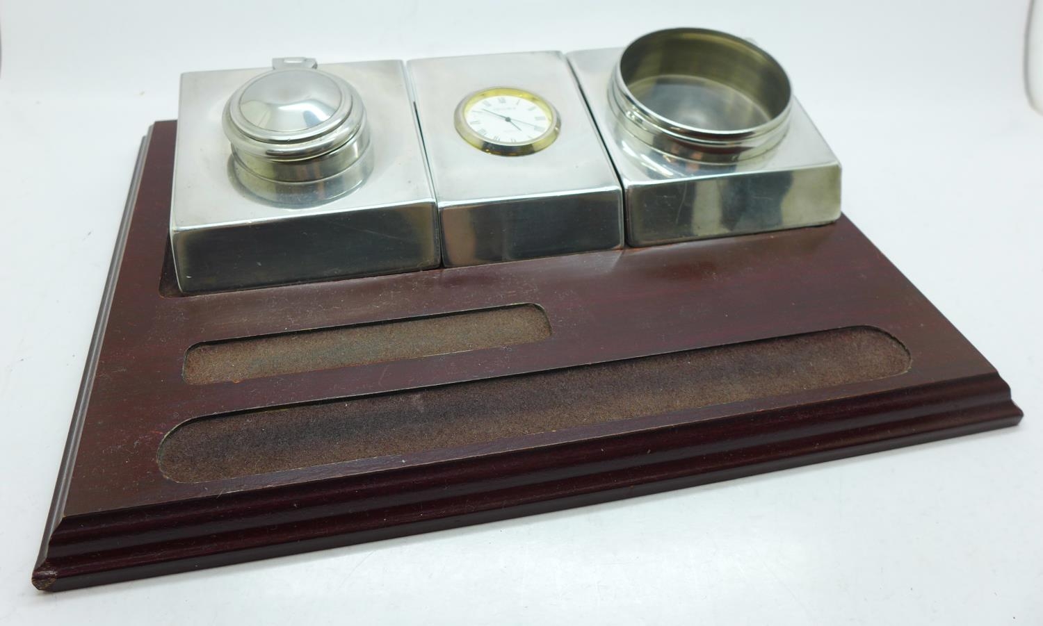 A modern desk tidy with clock and ink