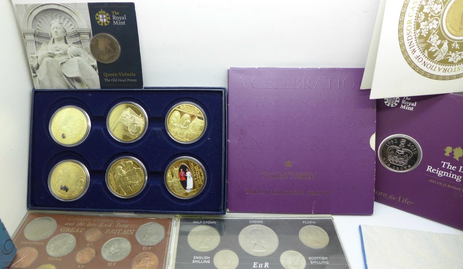 A collection of commemorative coin sets including four £5 coins, a 2002 ...