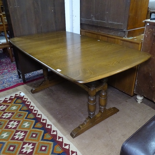 A modern Ercol dark elm extending dining table, with integra... | Barnebys
