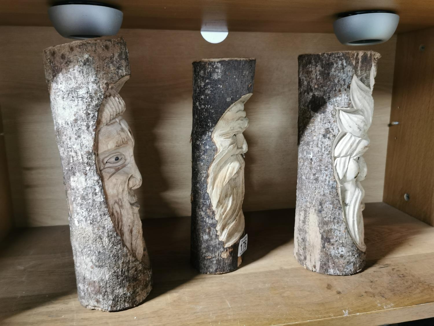 Three Logs With Carved Faces