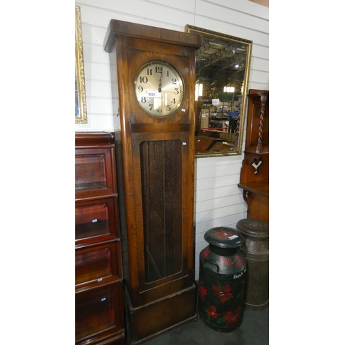 A 1920s vintage Oak longcase clock with a glass door enclosing a ...