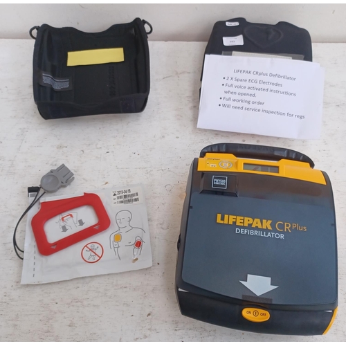 A cased Lifepak CR Plus defibrillator with two spare ECG electrodes ...