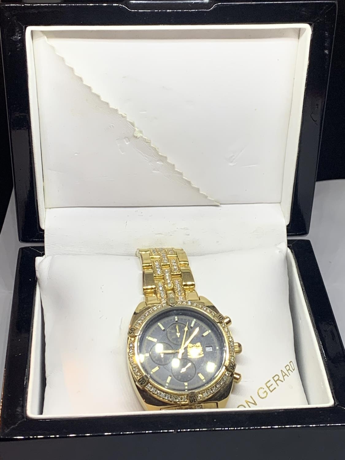 AN ASTON GERARD GOLD PLATED WATCH WITH DIAMONDS IN A PRESENTATION BOX